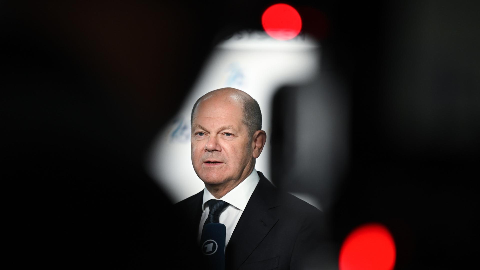 Frankfurt am Main - Sicherheitspanne: Mann fährt im Kanzler-Konvoi mit und umarmt Scholz