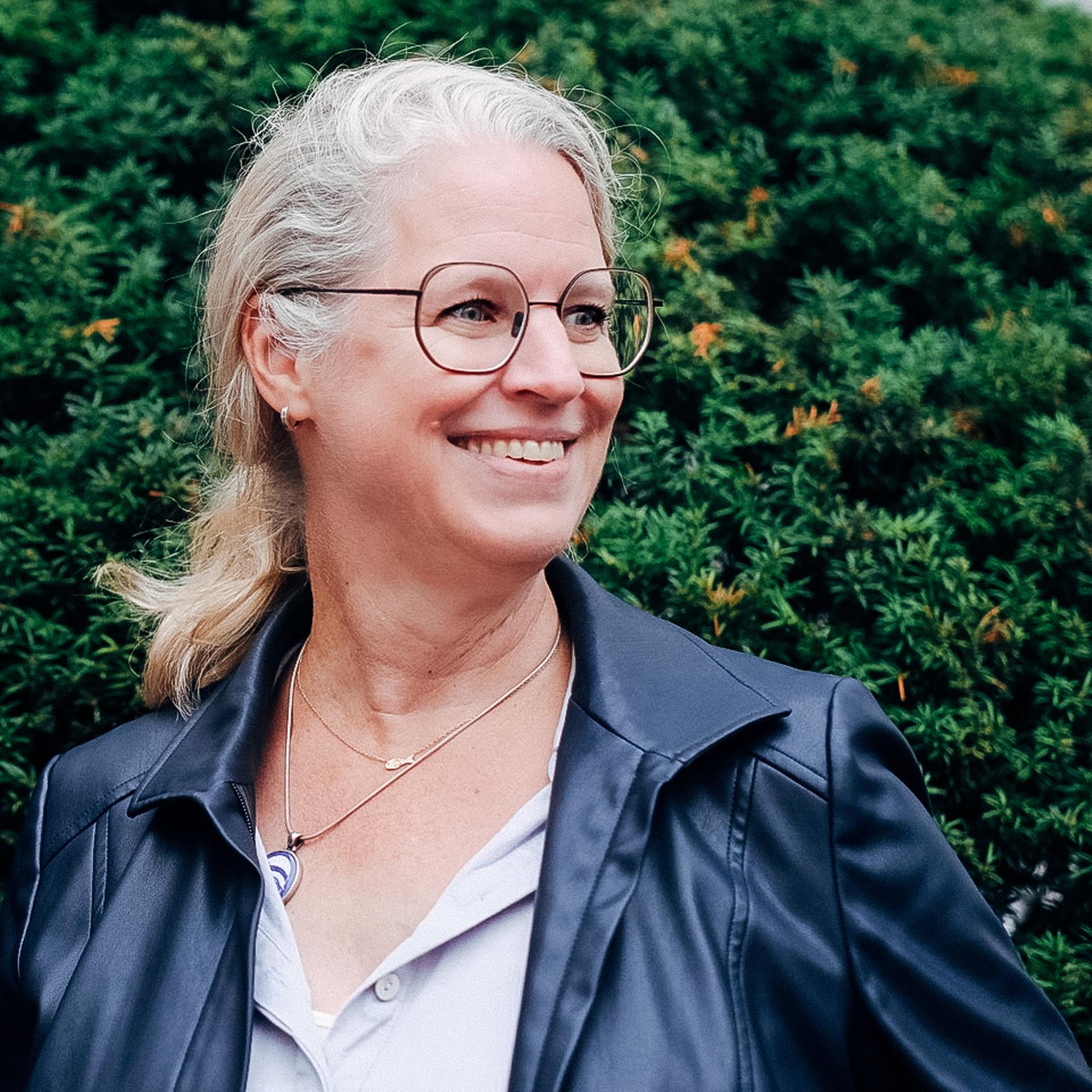 Isabel Bogdan vor einer grünen Hecke